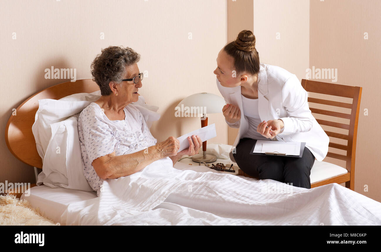 Old woman with senior social work assistant Stock Photo - Alamy