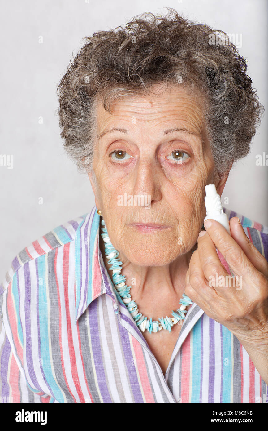 Senior woman between 70 and 80 years old and eye drops Stock Photo - Alamy
