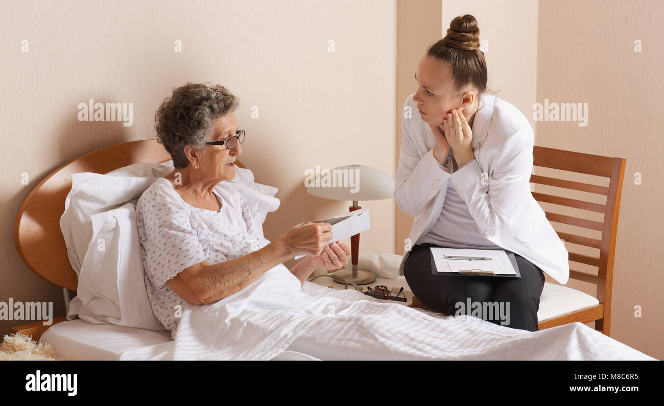 Old woman with senior social work assistant Stock Photo - Alamy