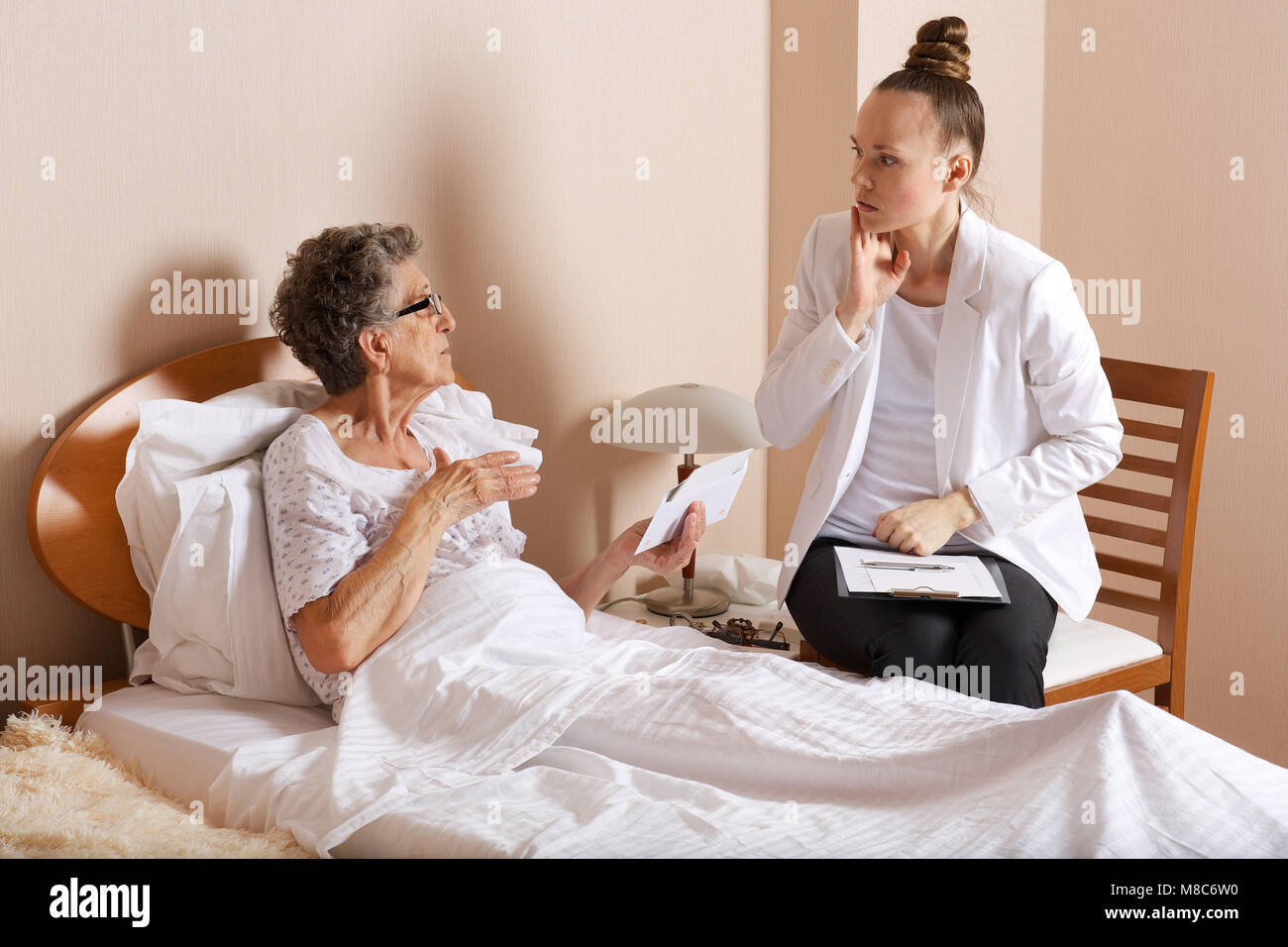Old woman with senior social work assistant Stock Photo - Alamy