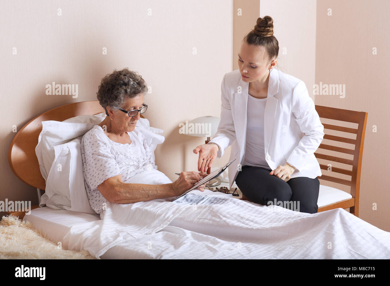 Old woman with senior social work assistant Stock Photo - Alamy