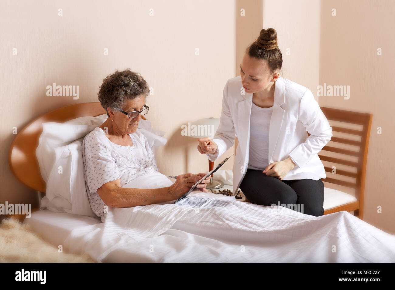 Old woman with senior social work assistant Stock Photo - Alamy