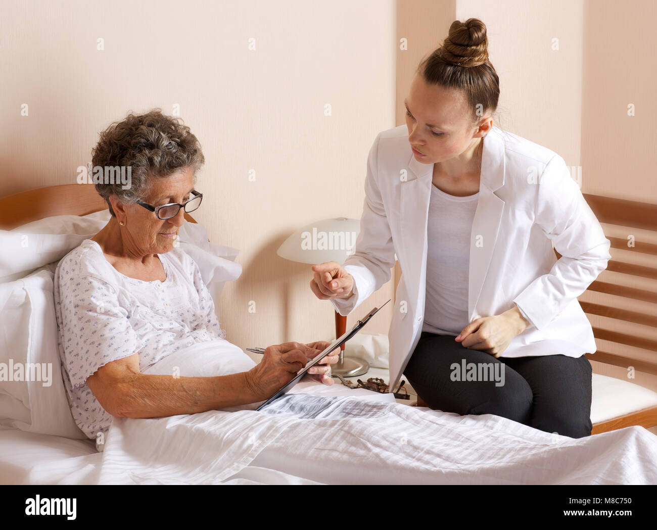 Old woman with senior social work assistant Stock Photo - Alamy