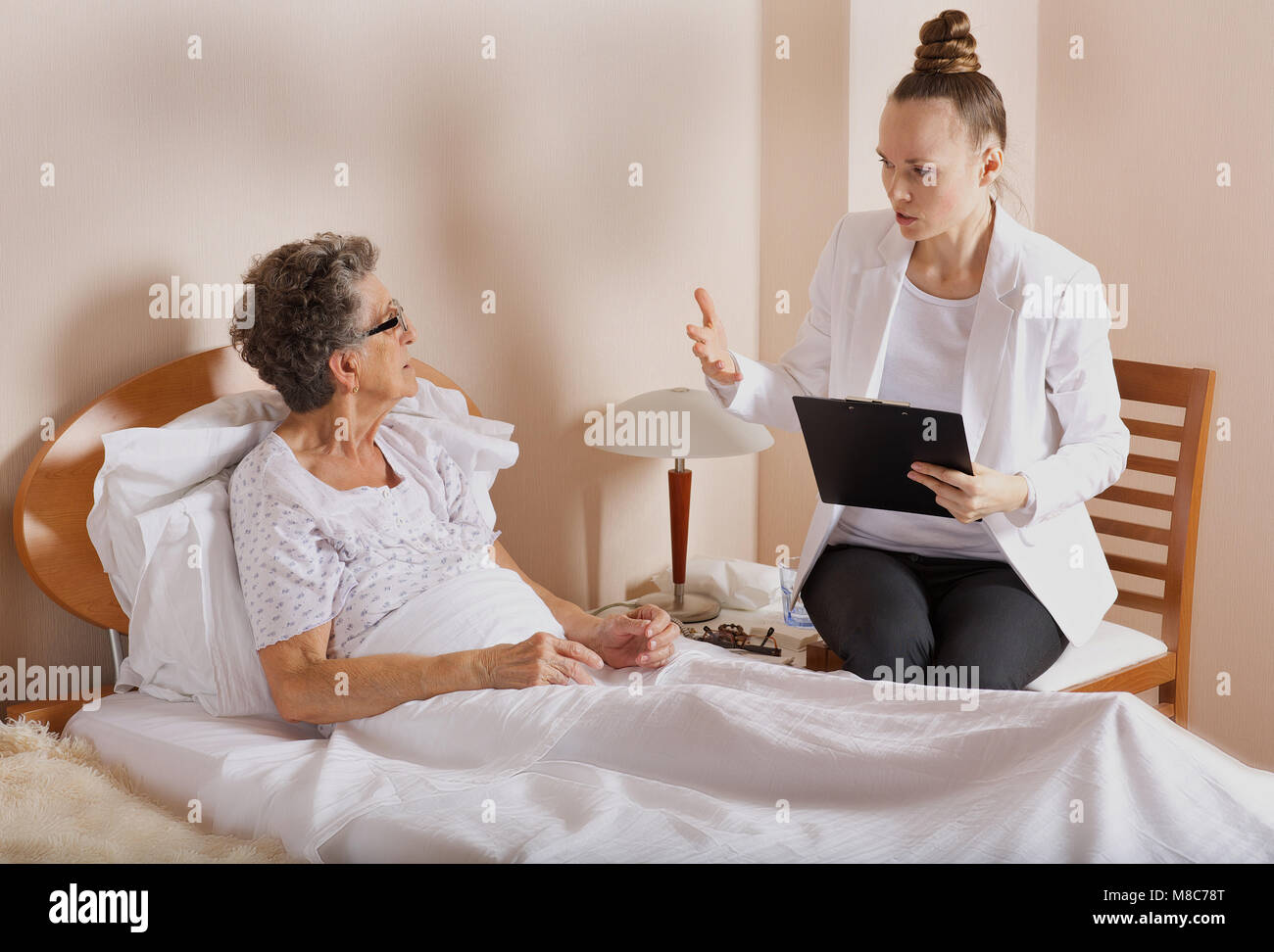 Old woman with senior social work assistant Stock Photo - Alamy