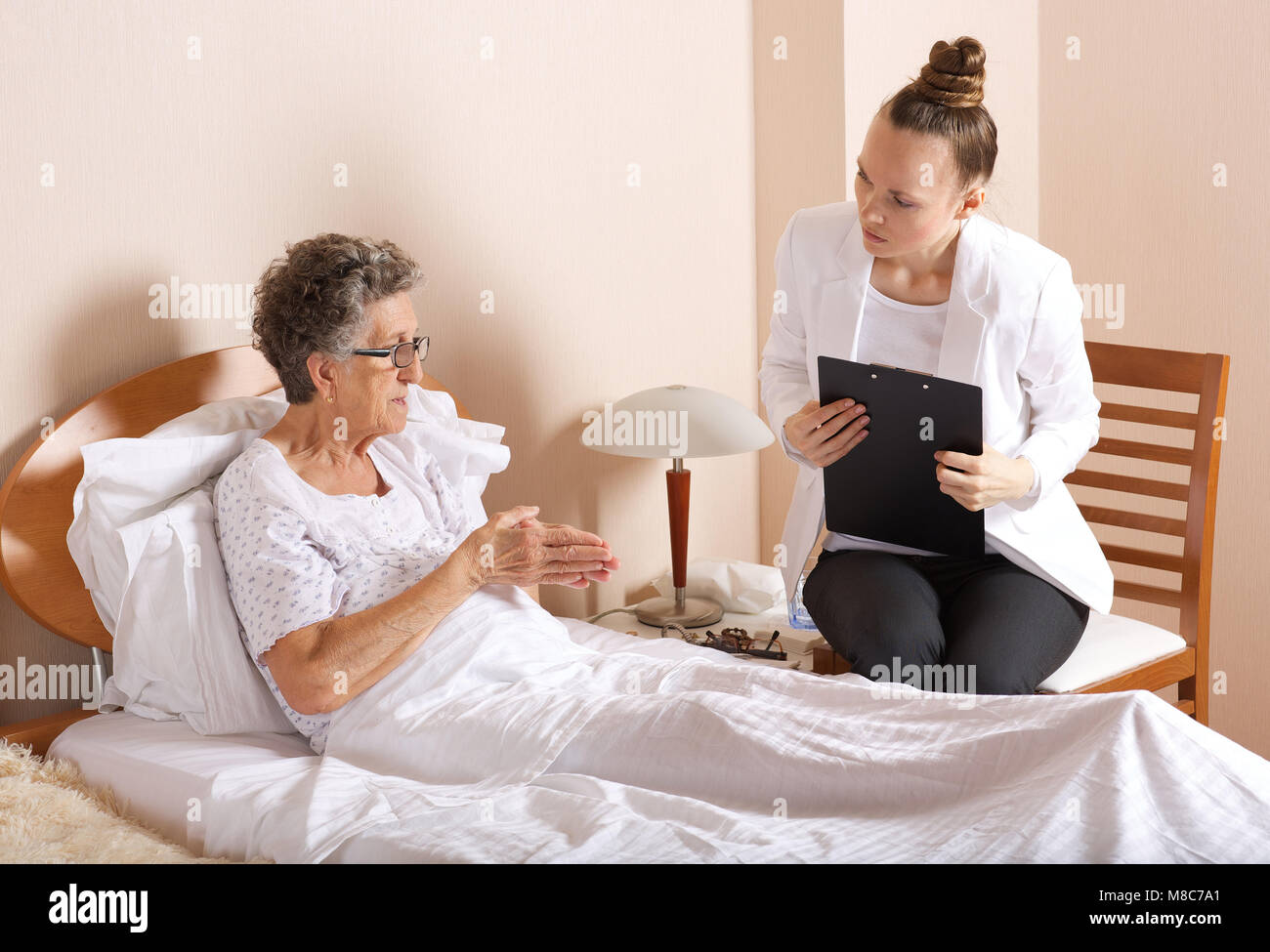 Old woman with senior social work assistant Stock Photo - Alamy