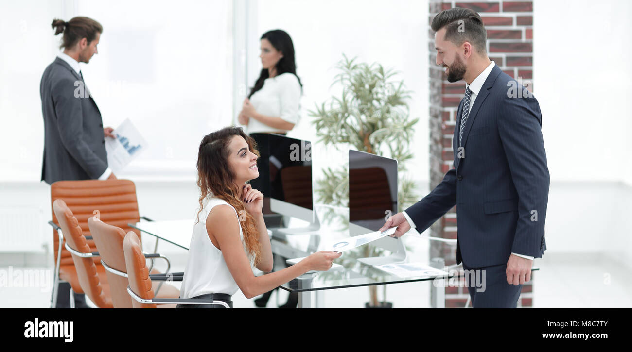 Manager handing the employee the document Stock Photo - Alamy