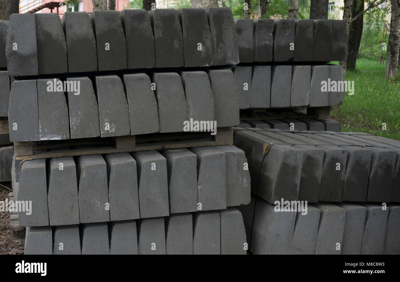 Stack of concrete curbstone. Construction process Stock Photo - Alamy