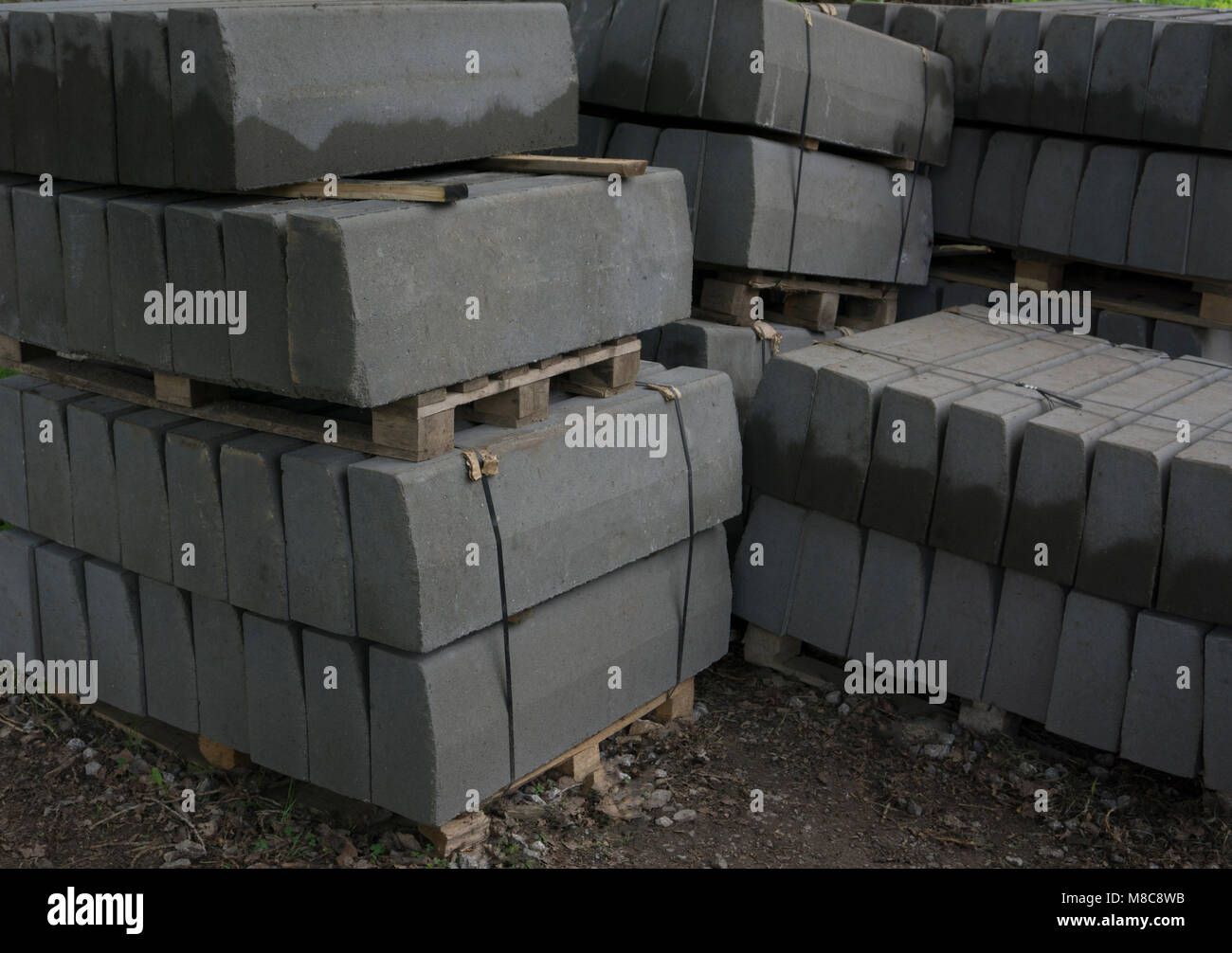 Stack of concrete curbstone. Construction process Stock Photo - Alamy