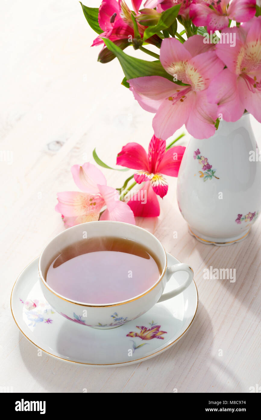Retro still life with cup of tea and flowers (Alstroemeria Stock Photo ...