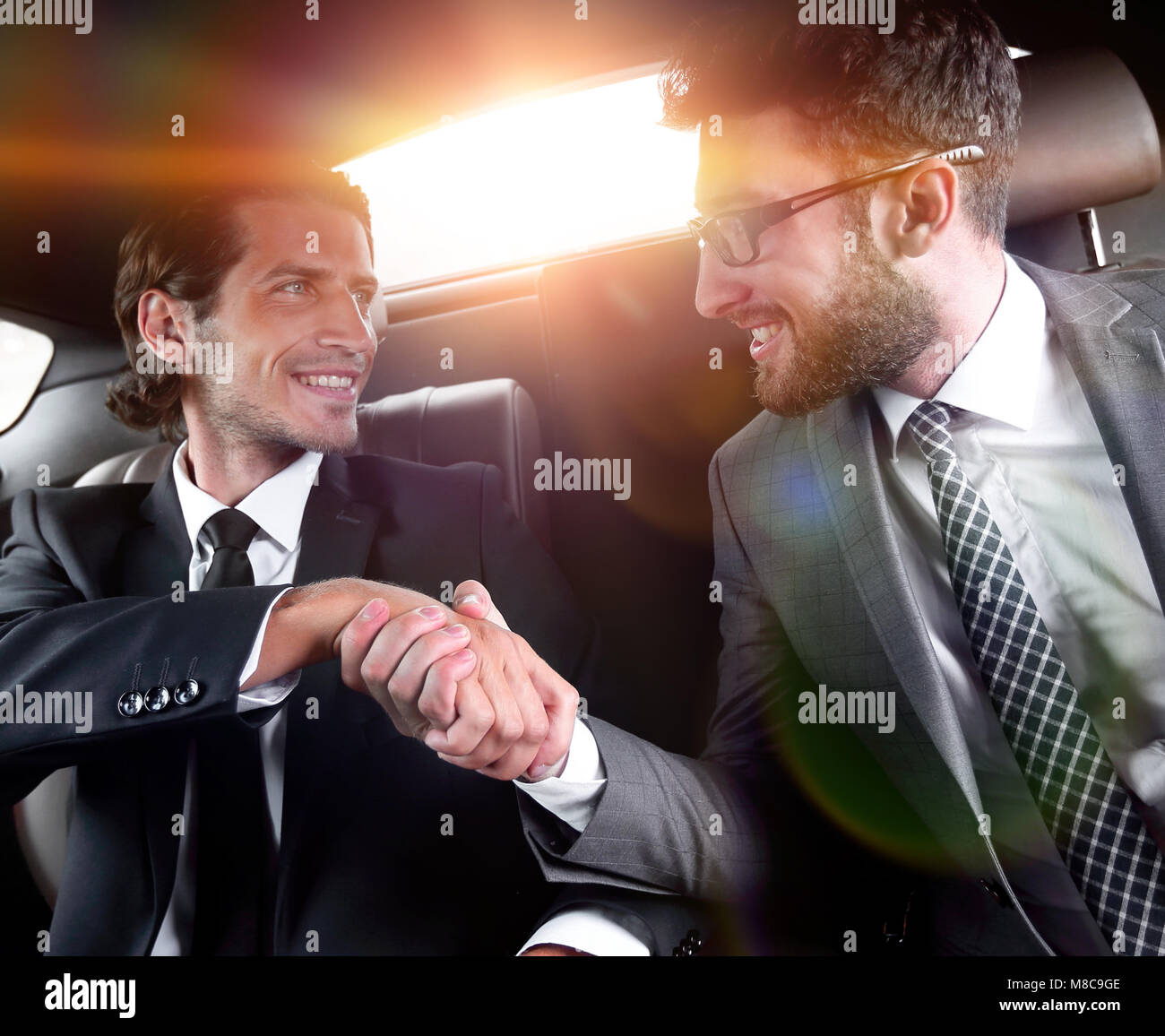 handshake of business partners sitting in the car Stock Photo - Alamy