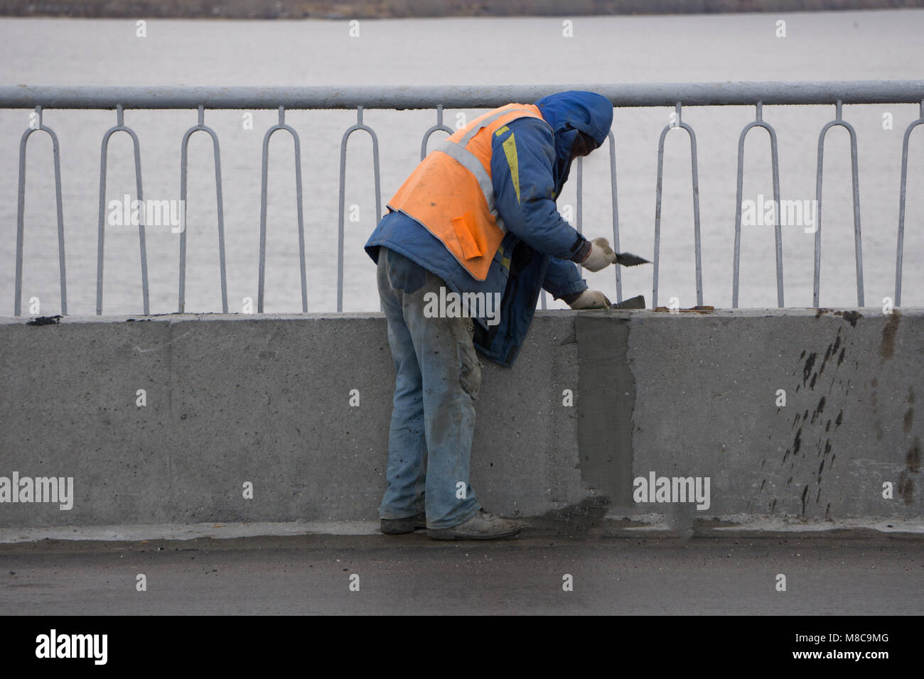 Builder man repairing a bridge Stock Photo - Alamy