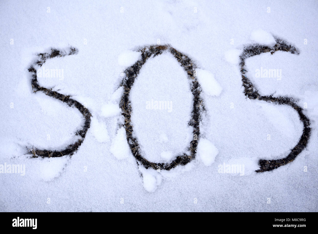 SOS sign for help needed written in the snow Stock Photo - Alamy