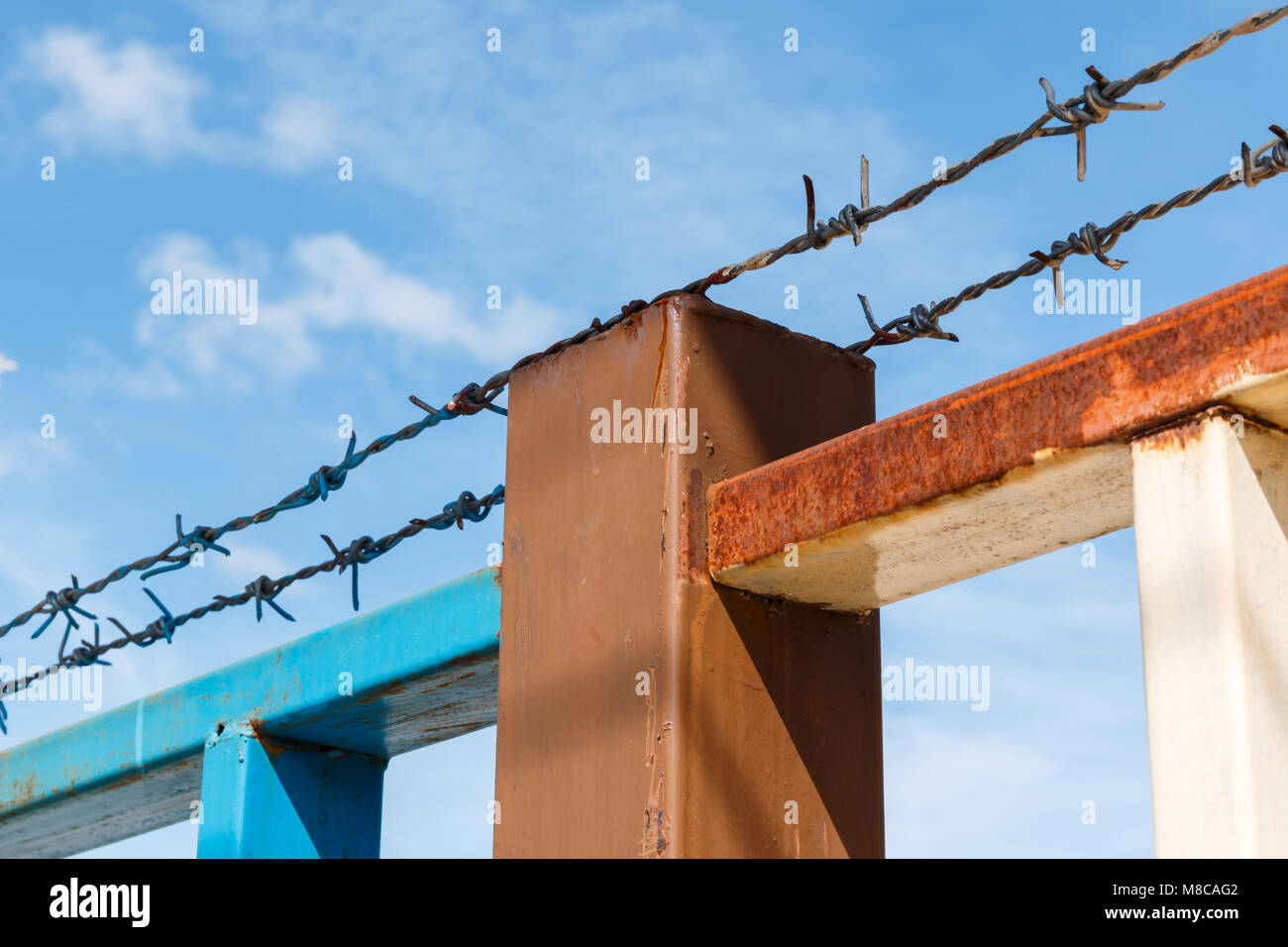 Barbed wire on rusty fence Stock Photo - Alamy