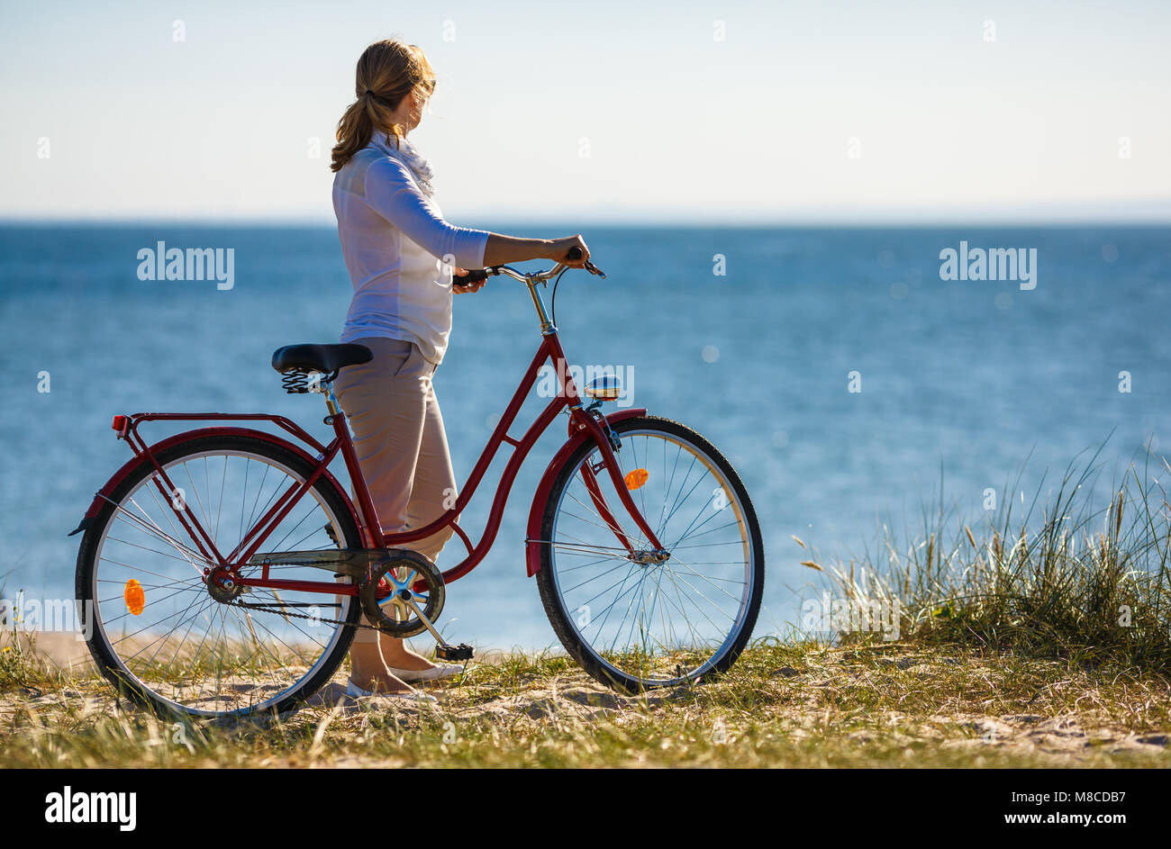 Woman relaxing with bike at seaside Stock Photo - Alamy