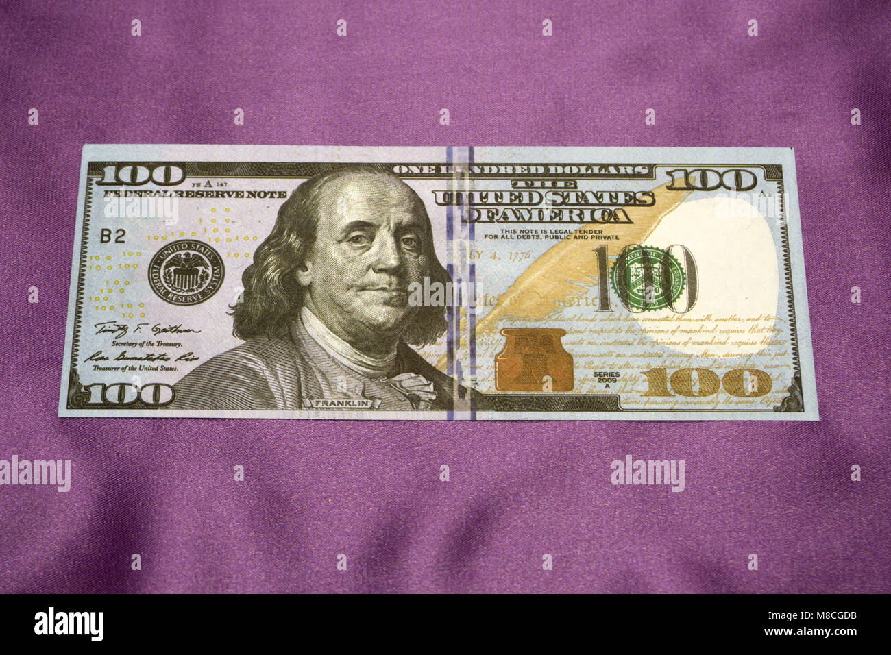100 dollars banknotes on a purple background Stock Photo - Alamy