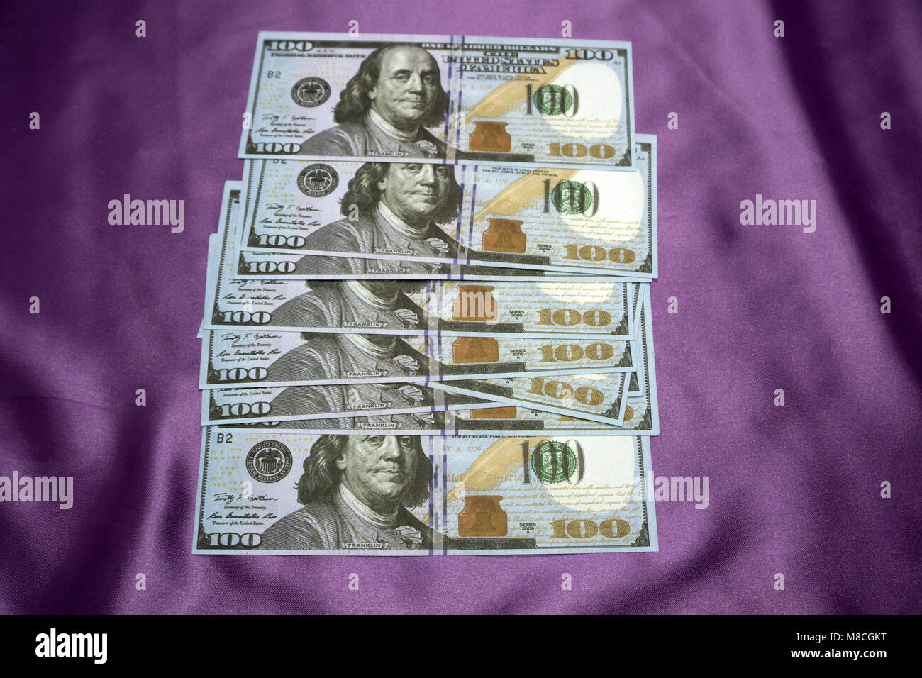 100 dollars banknotes on a purple background Stock Photo - Alamy
