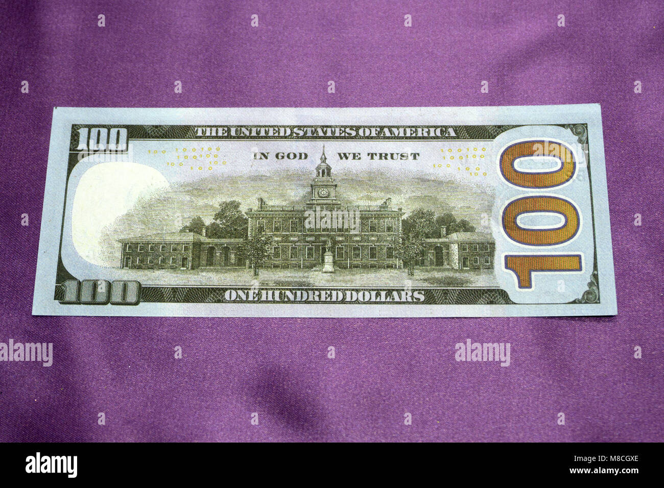 100 dollars banknotes on a purple background Stock Photo - Alamy