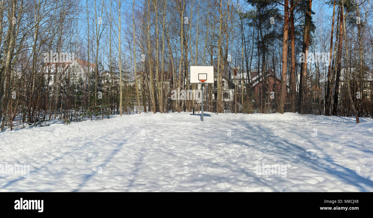 An empty basketball court in a snow-covered forest near a European ...