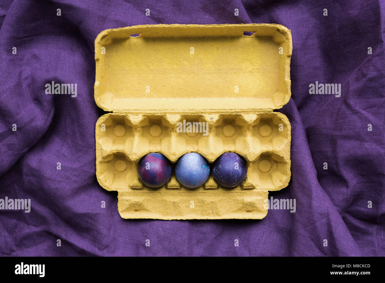 Three Easter eggs in carton on textile background Stock Photo - Alamy