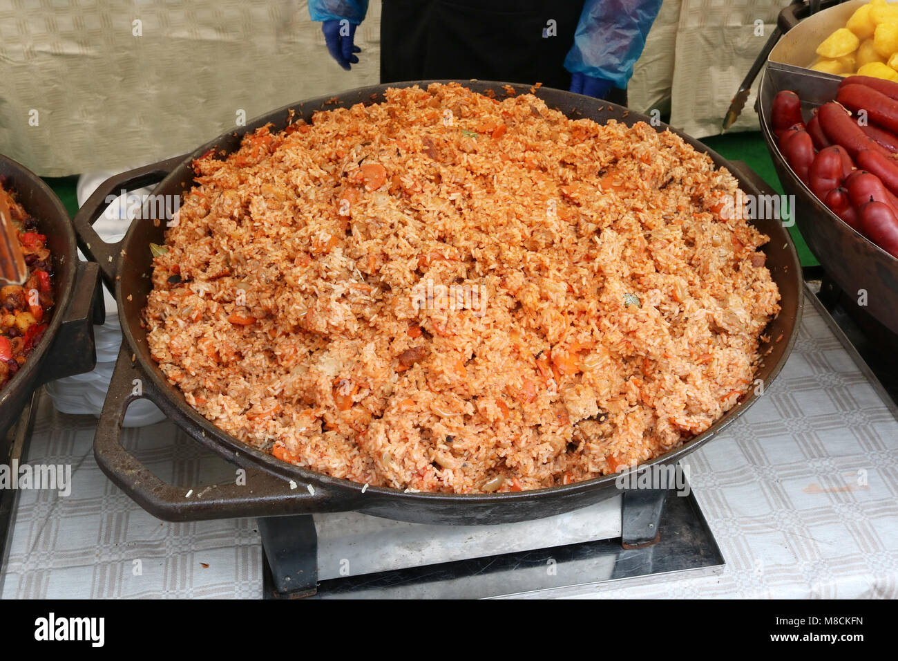 Fast food of the big city - metal big frying pan with red hot fat pilaf ...