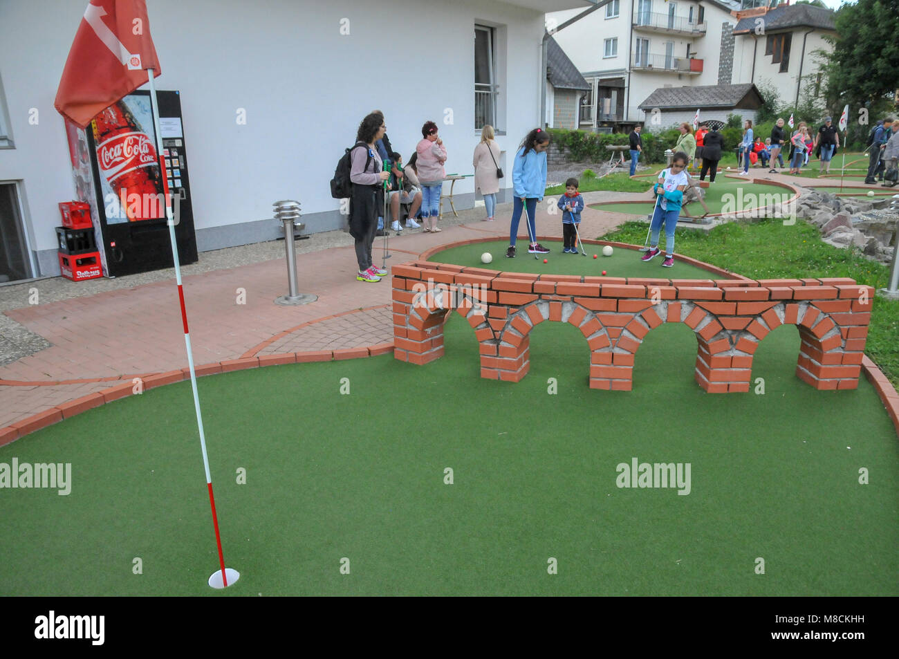 Families putting on a mini golf or putting course Stock Photo - Alamy