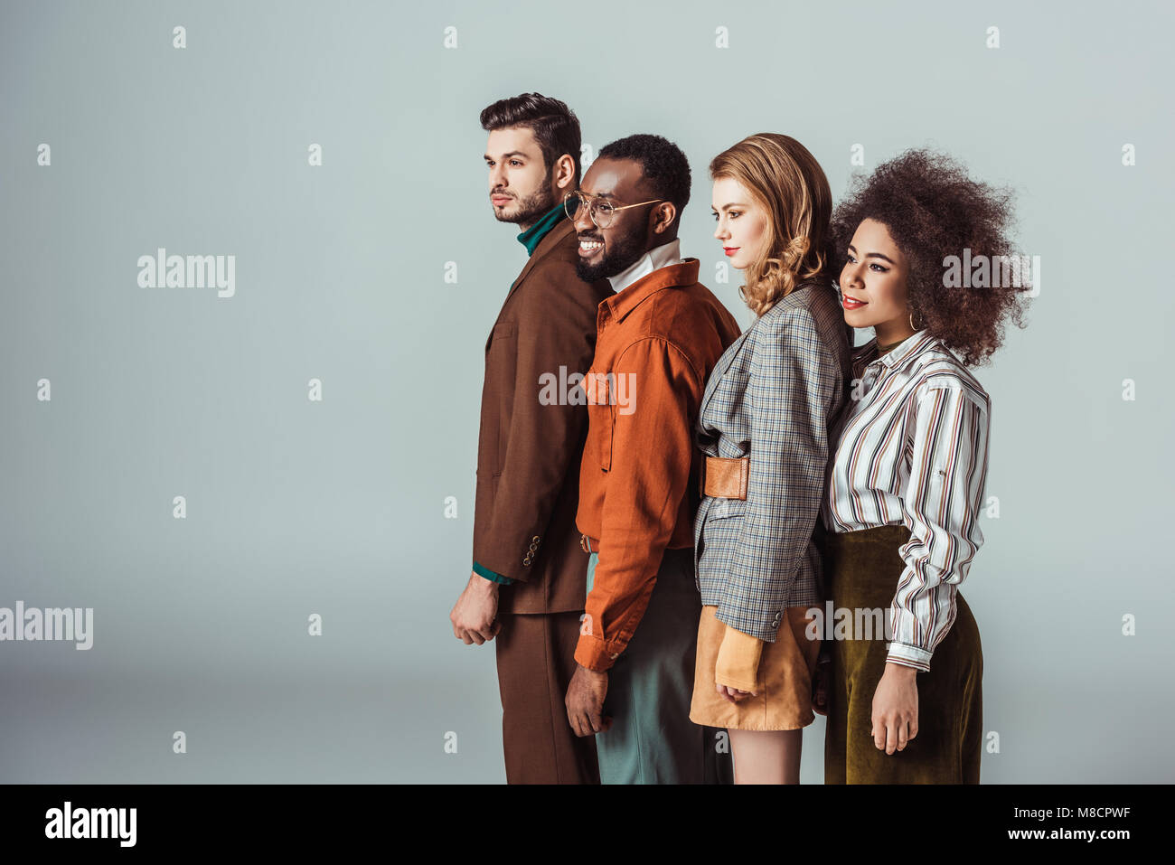 side view of smiling multicultural retro styled friends looking away ...