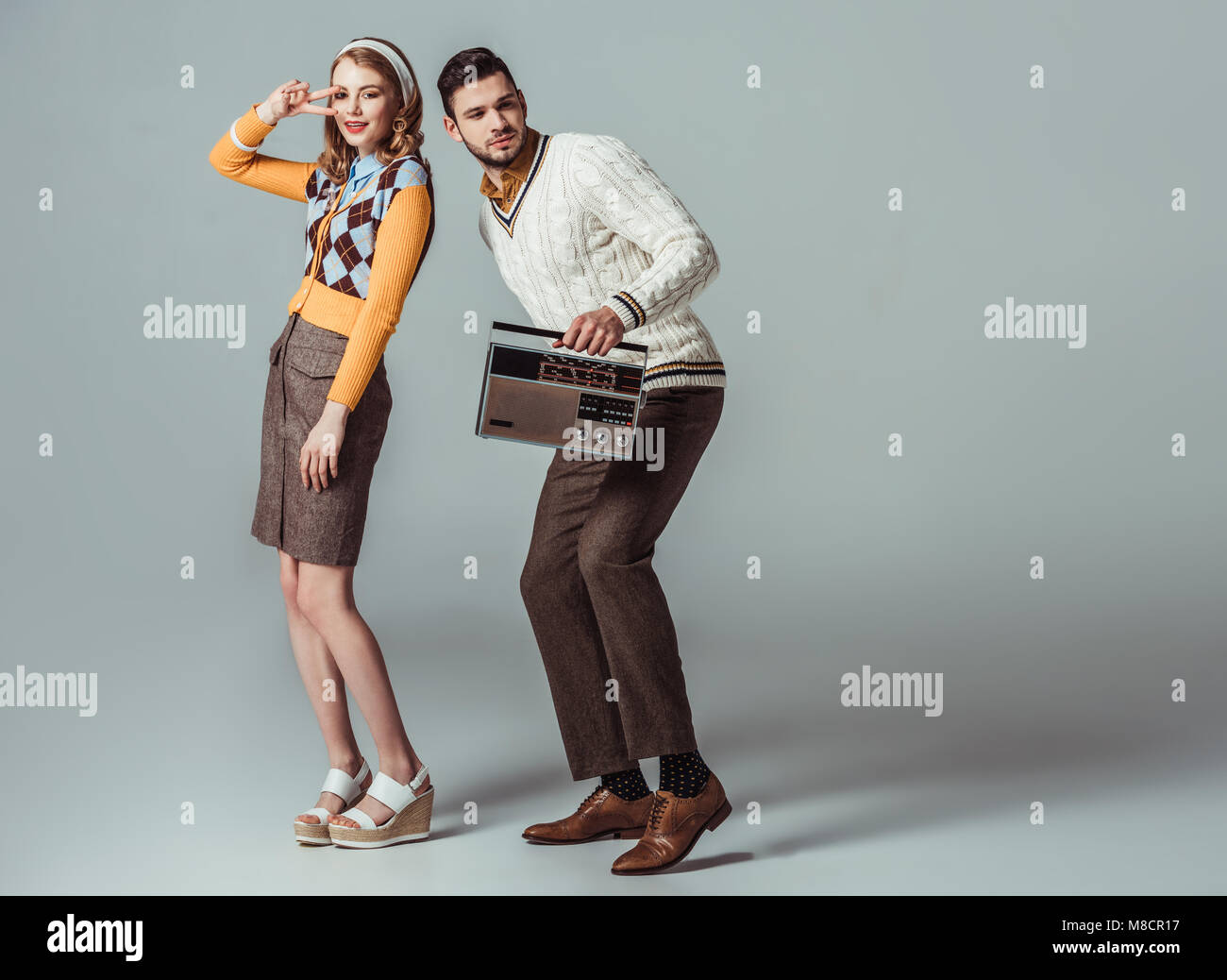beautiful retro styled couple dancing with vintage radio on grey Stock ...