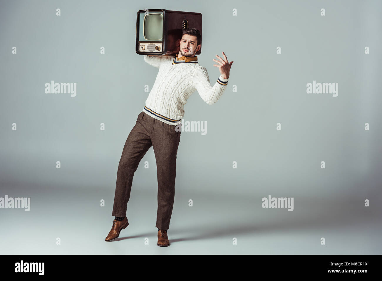 retro styled handsome man posing with vintage television on shoulder ...