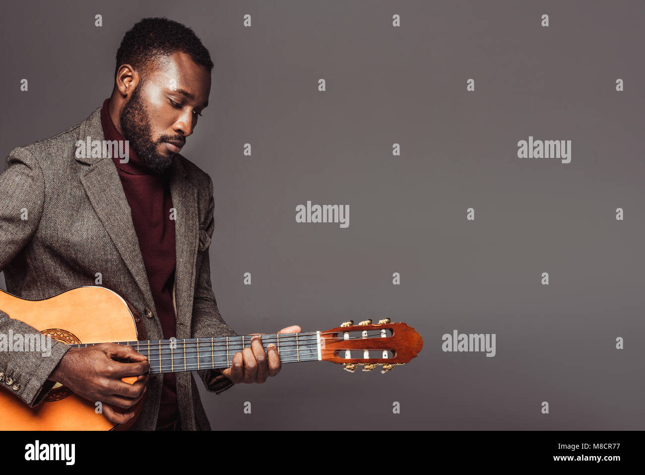 african american retro styled guitarist playing acoustic guitar ...