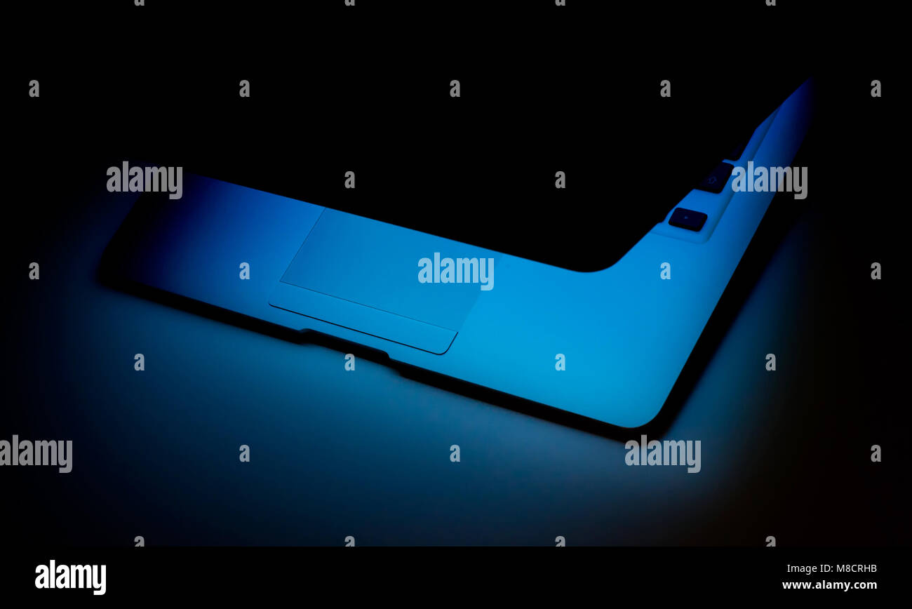 Laptop computer with screen half open on dark background isolated with ...