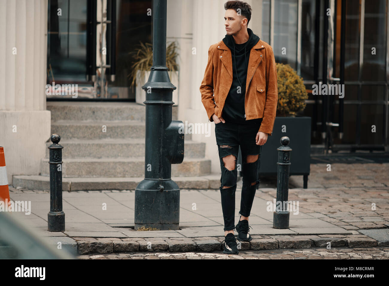 Model looking man stand on the city street with cars background, look ...