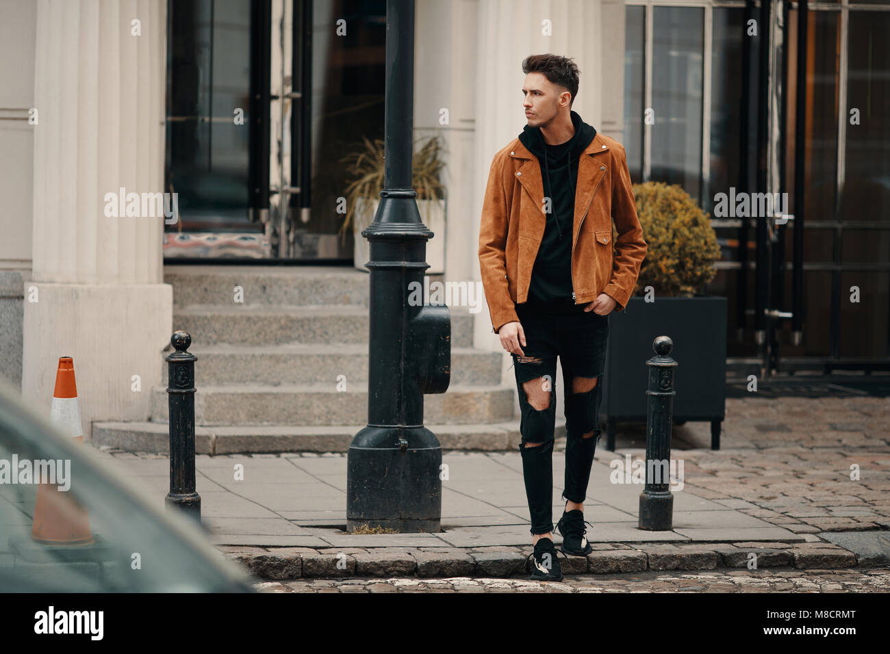 Model looking man stand on the city street with cars background, look ...