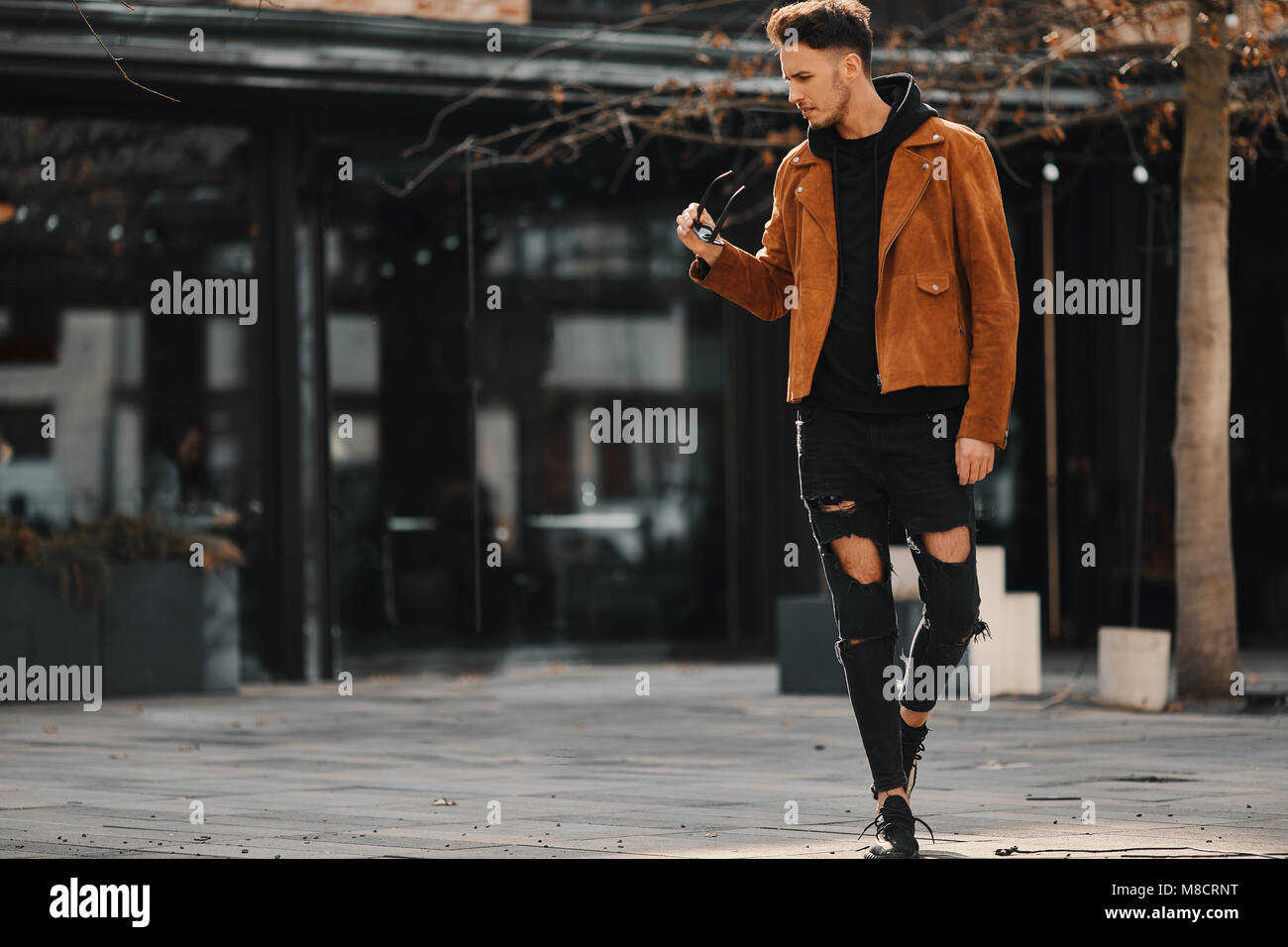 Model looking man stand on the city street with cars background, look ...