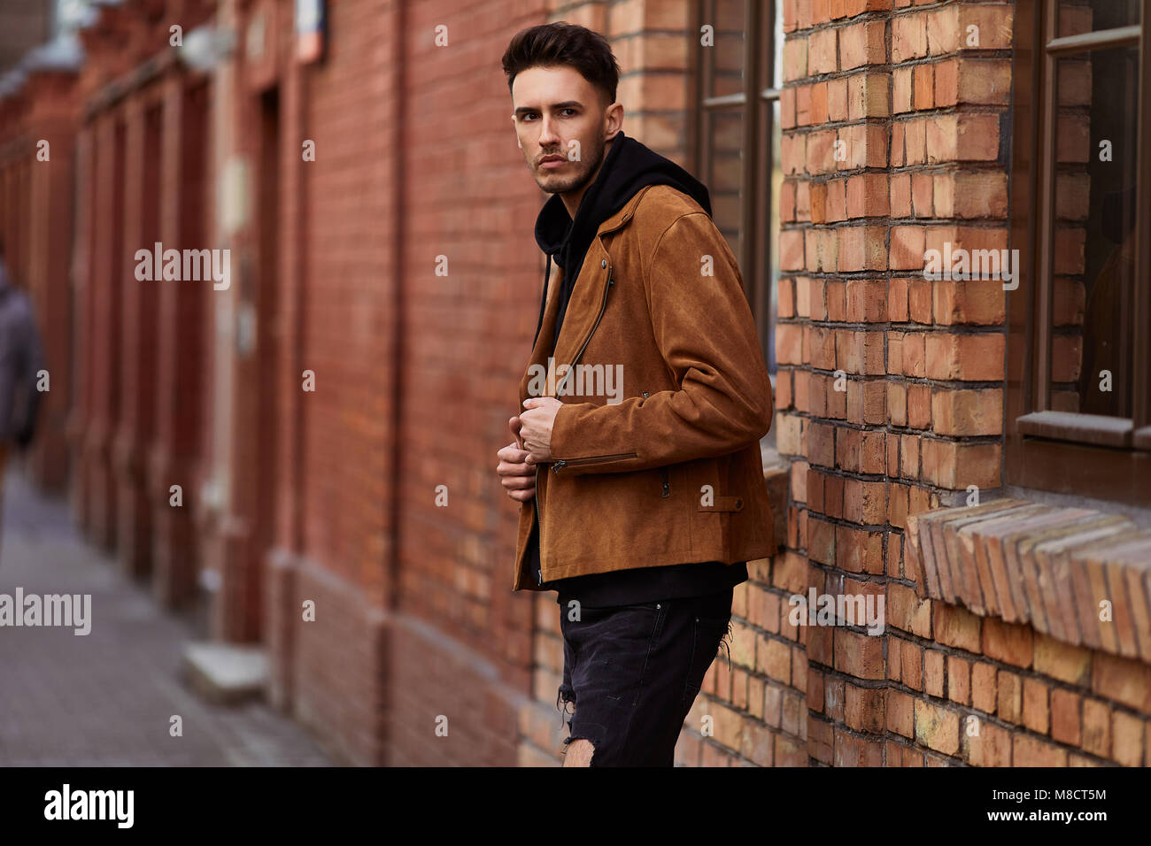 Model looking man stand near the wall and look on his watch Stock Photo ...