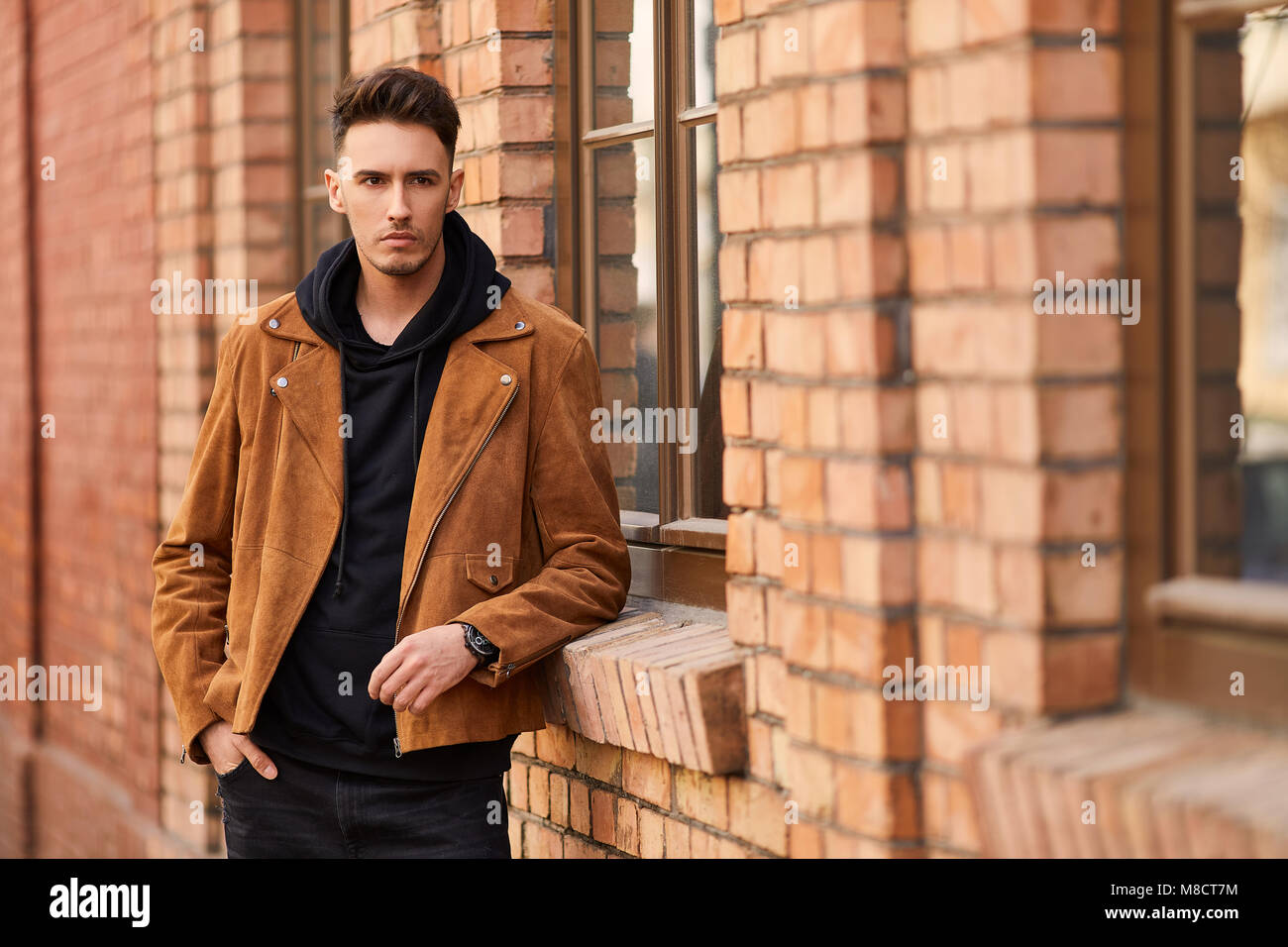 Model looking man stand near the wall and look on his watch Stock Photo ...