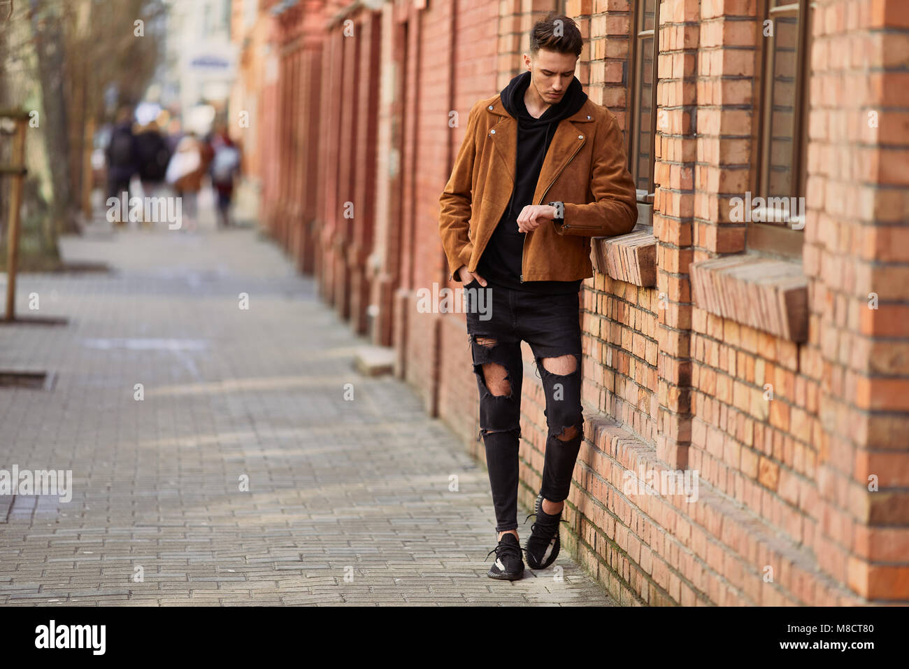 Model looking man stand near the wall and look on his watch Stock Photo ...