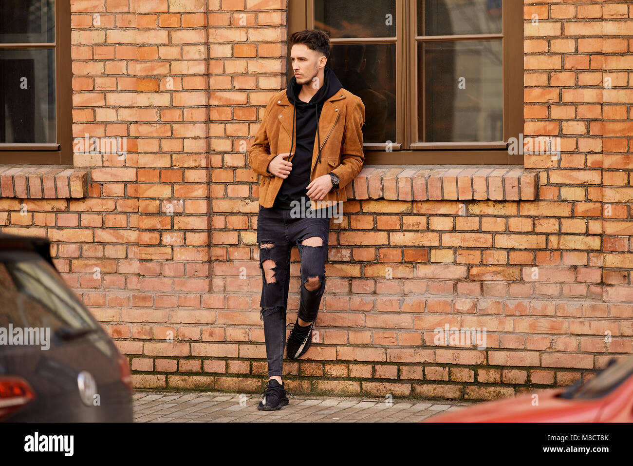 Model looking man stand near the wall and look on his watch Stock Photo ...