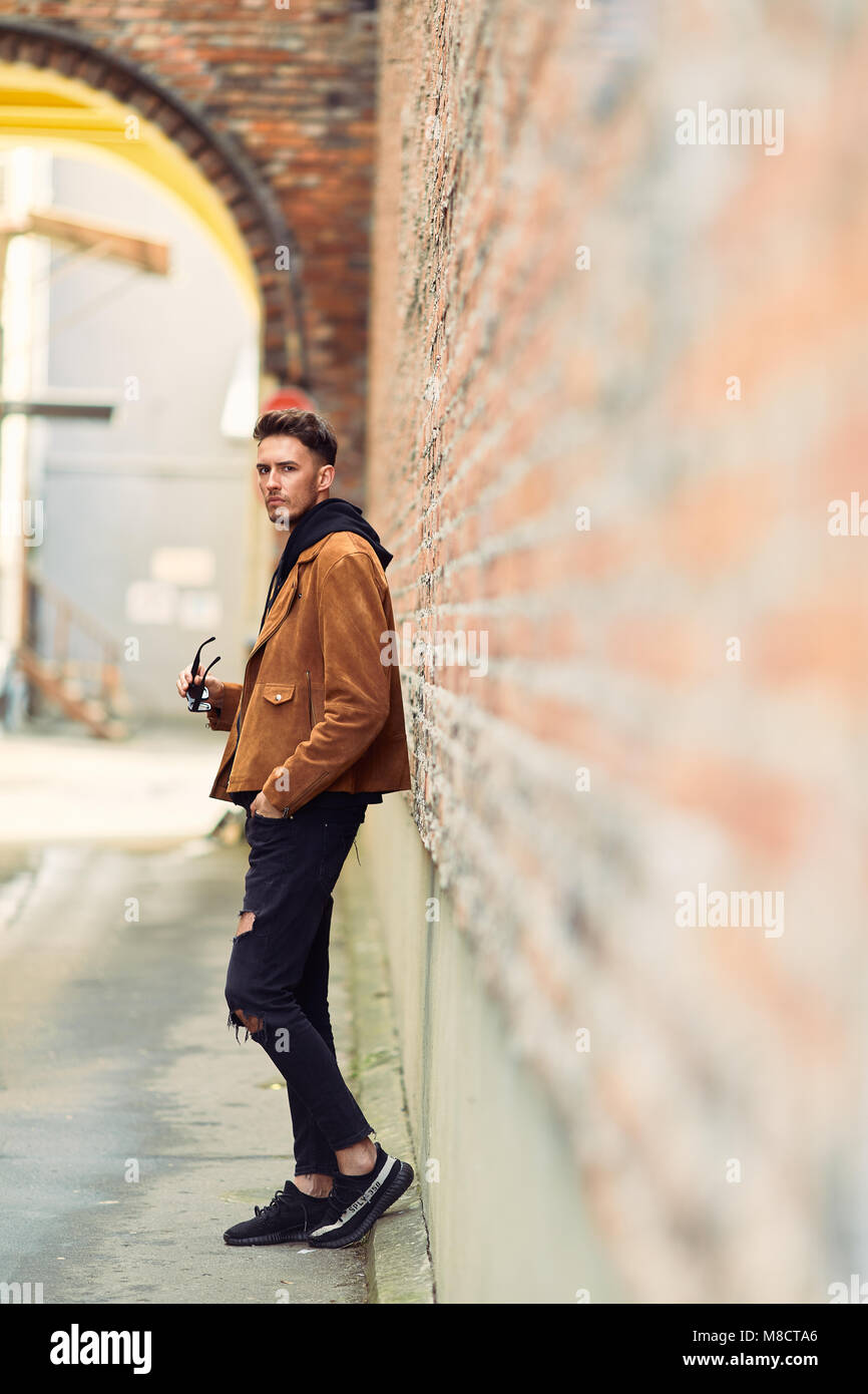Model looking man stand near the wall and look on his watch Stock Photo ...