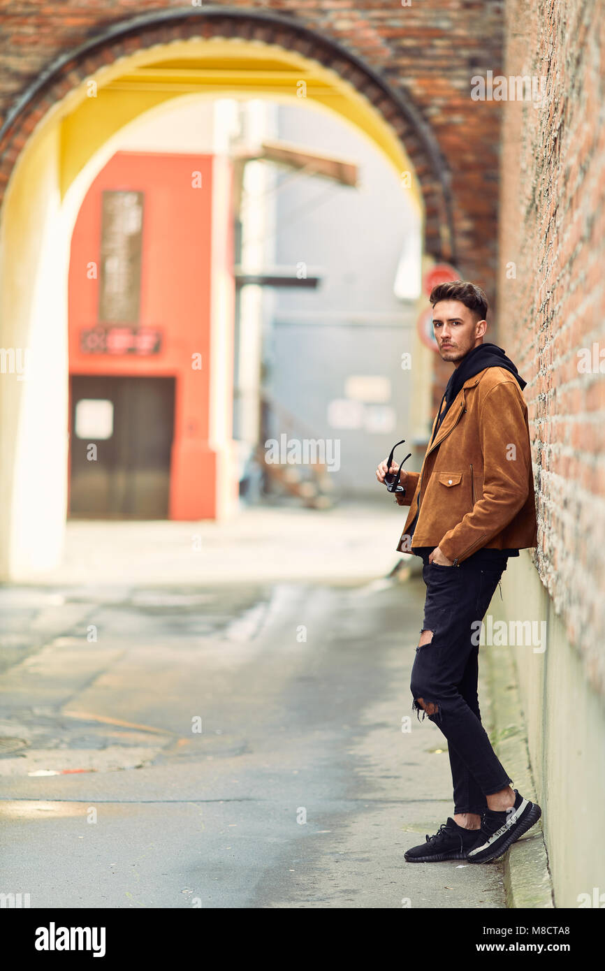Model looking man stand near the wall and look on his watch Stock Photo ...