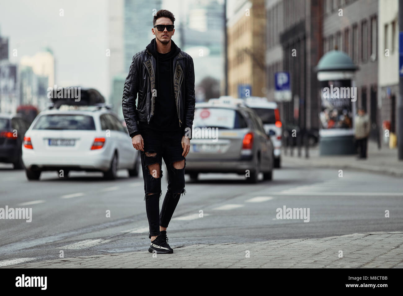 Model looking man stand on the city street with cars background, look ...