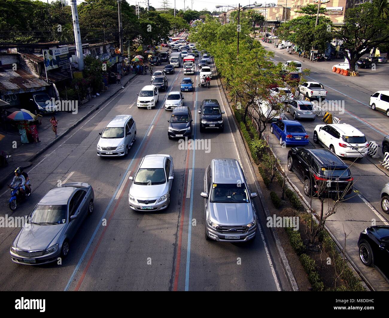 QUEZON CITY, PHILIPPINES - MARCH 9, 2018: Vehicles pass along a usually ...