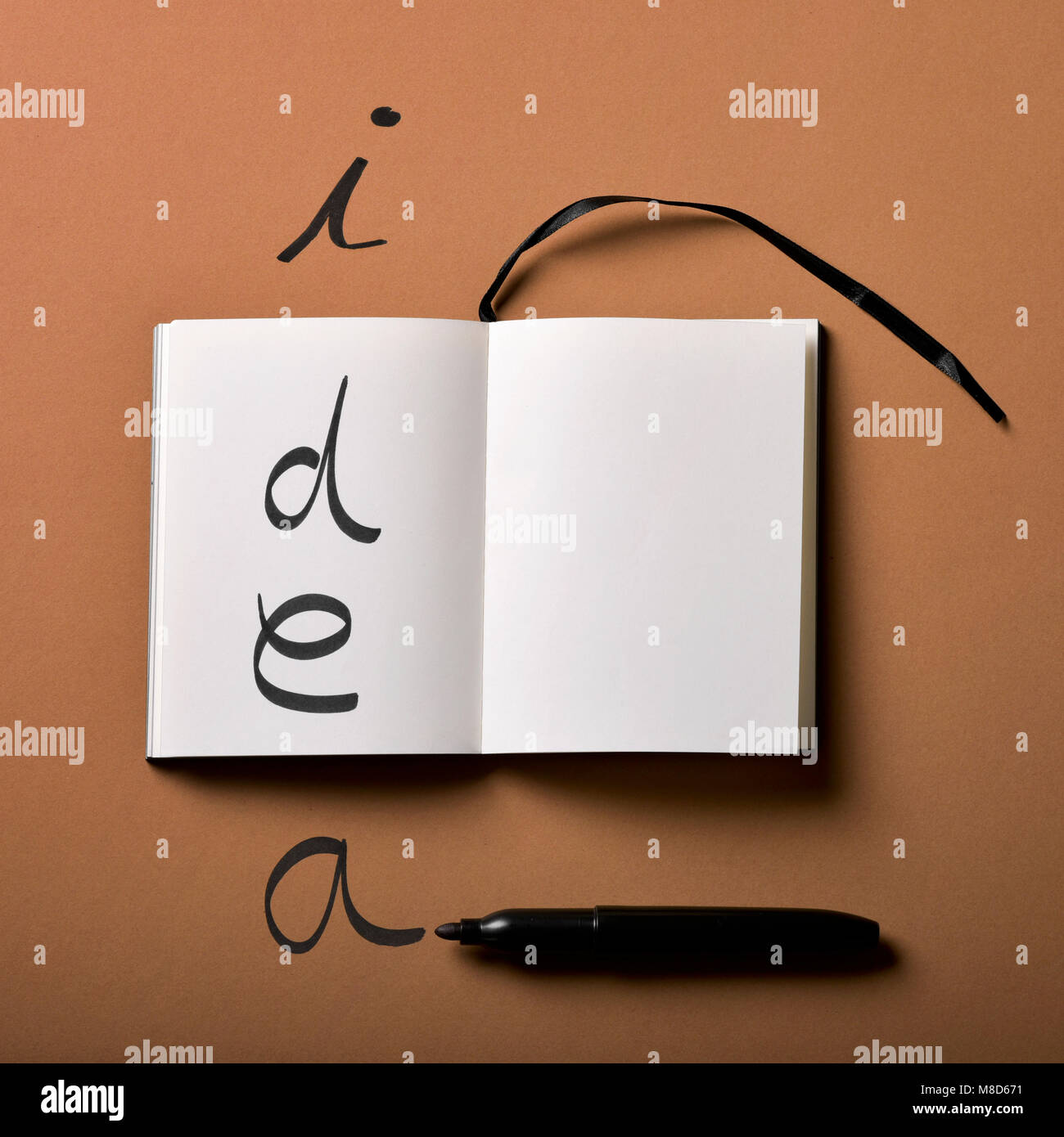 high angle view of an open notepad and a black marker pen, and the ...