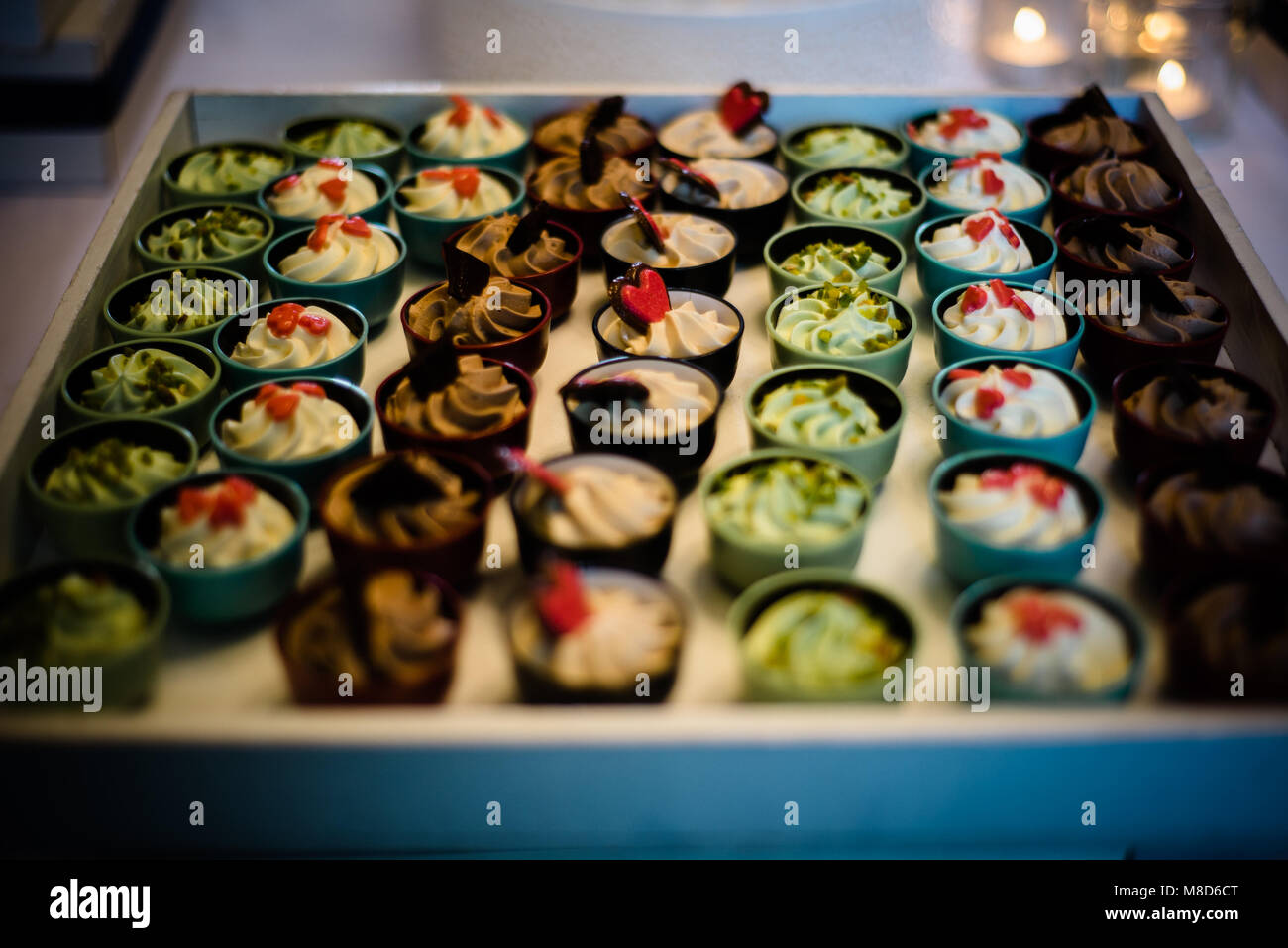 cup cakes of various sweets over tray in wedding party Stock Photo - Alamy