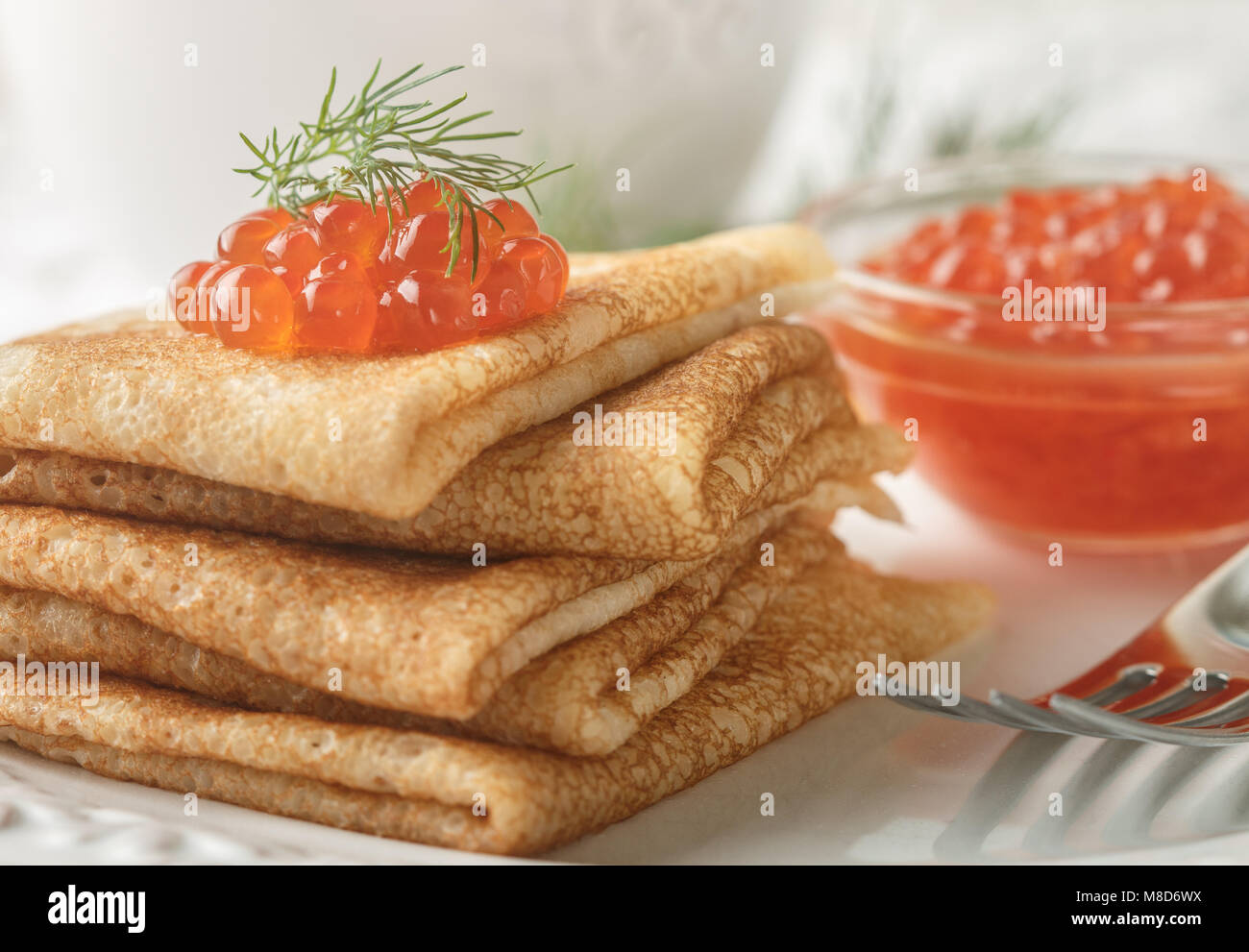 Traditional Russian pancakes (blini ) with salmon caviar on a white ...