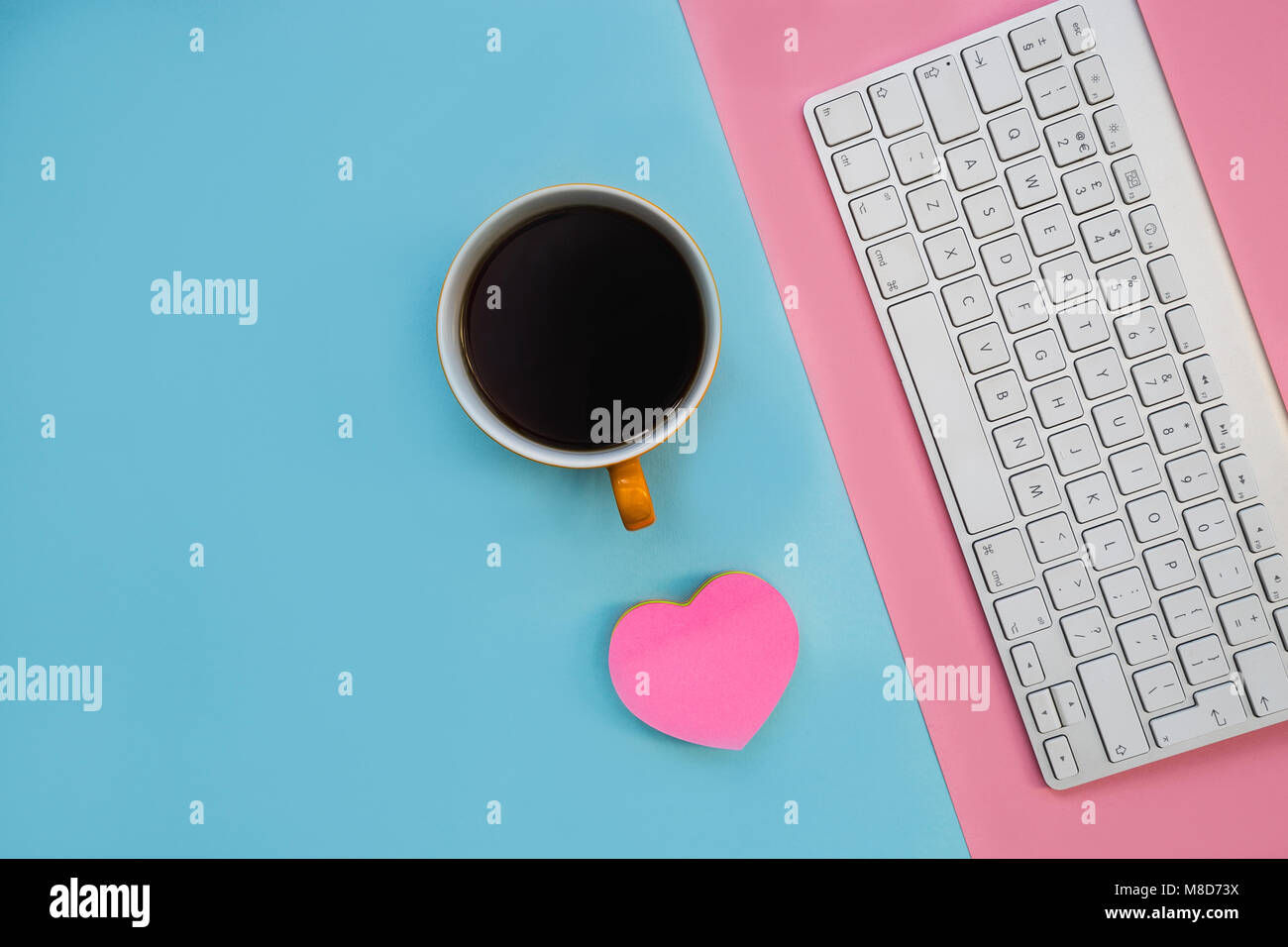 Minimal computer keyboard love heart overhead on bright blue background ...