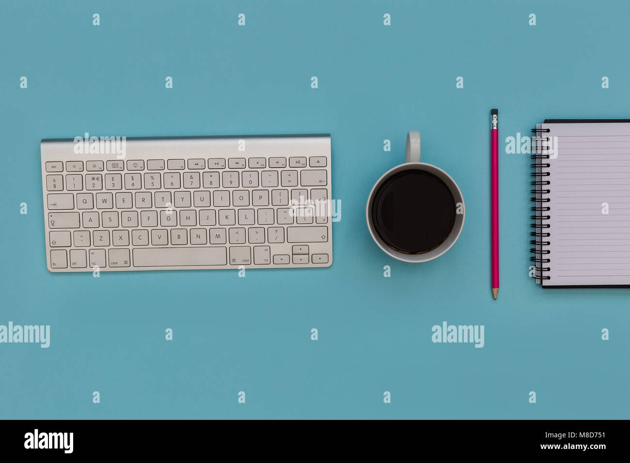 Minimal computer keyboard notebook overhead on bright blue background ...