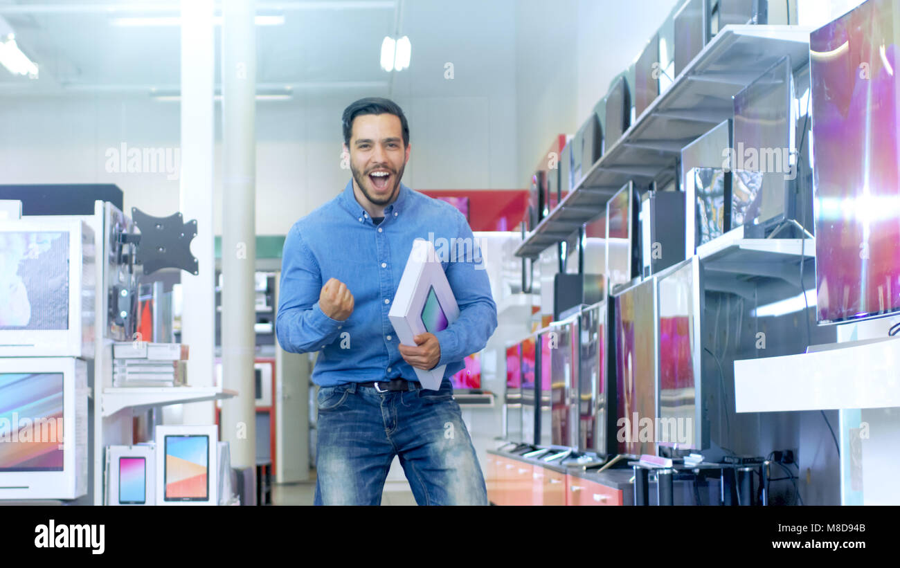 In the Electronics Store Young Man Holds Newly Purchased Computer ...