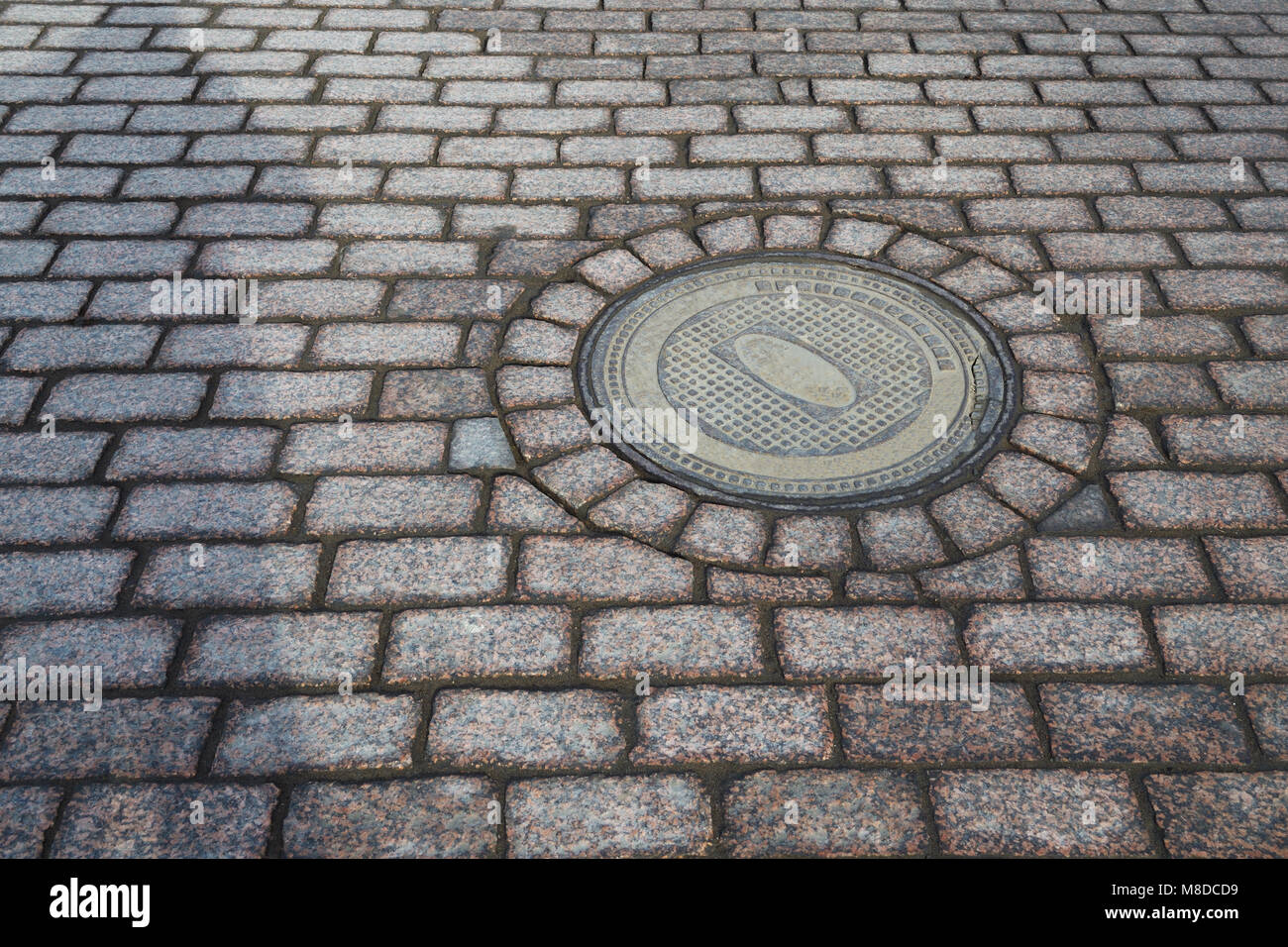 The pavement is tiled. On the surface hatch to the underground sewer ...