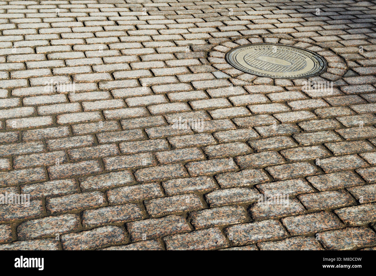 The pavement is tiled. On the surface hatch to the underground sewer ...