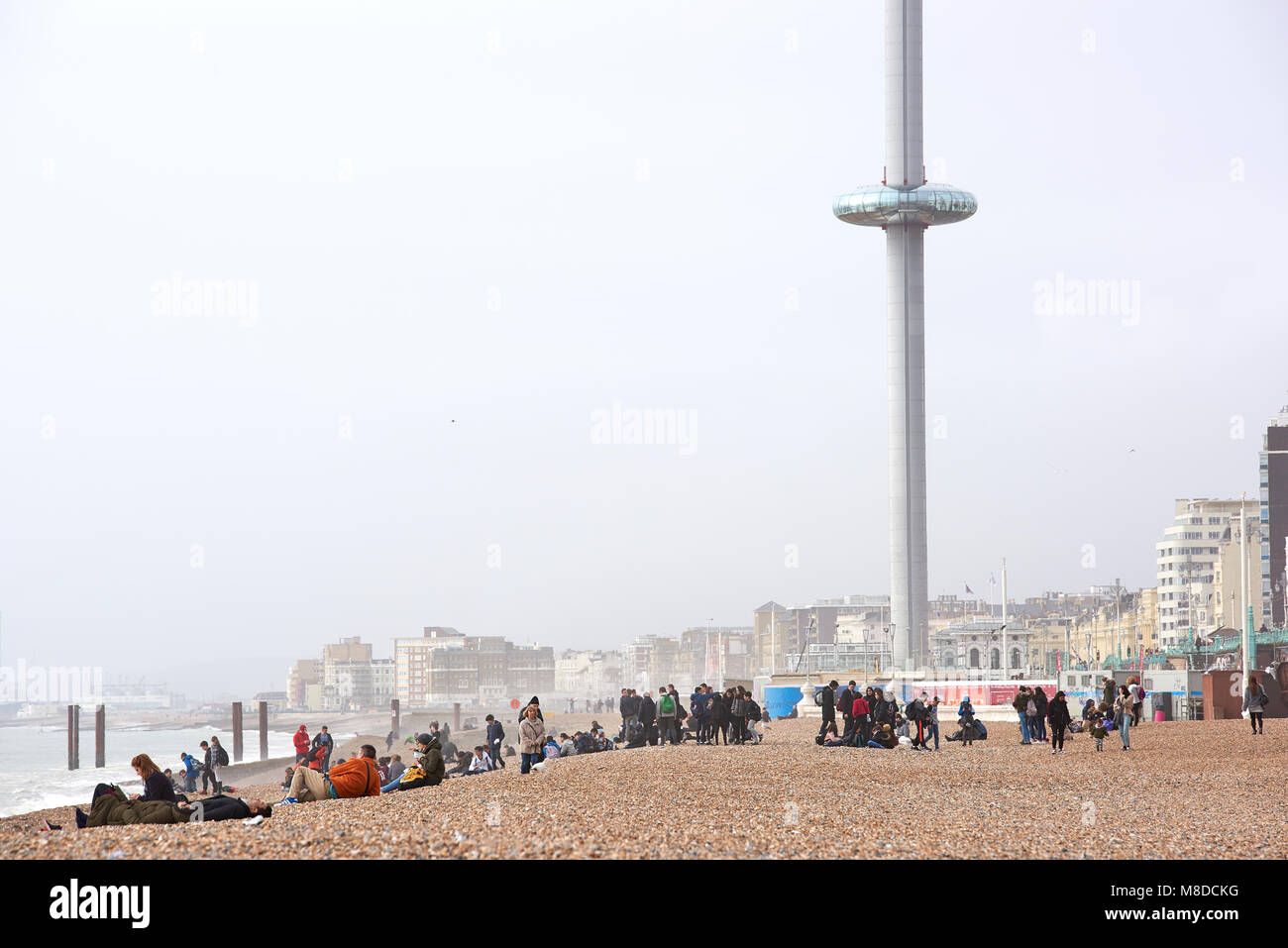 Beach in Brighton with beach goers and British airways moving ...